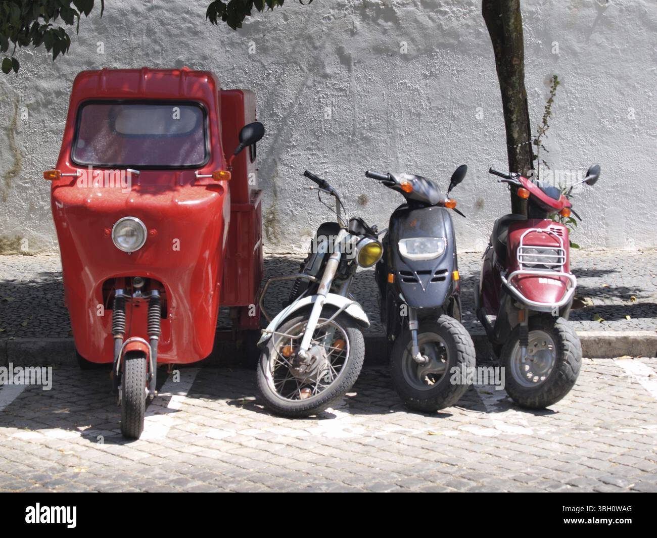 Traditional red Ape Tricycle, next to it three mopeds Stock Photo - Alamy