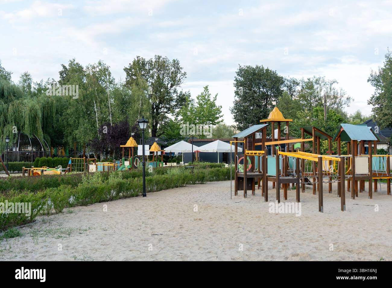 Modern outdoor playground with wooden climbing structures, rope bridges ...