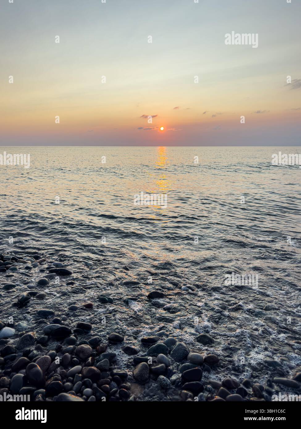 Pebble beach and sea waves at sunset on Black Sea in Batumi, Georgia ...