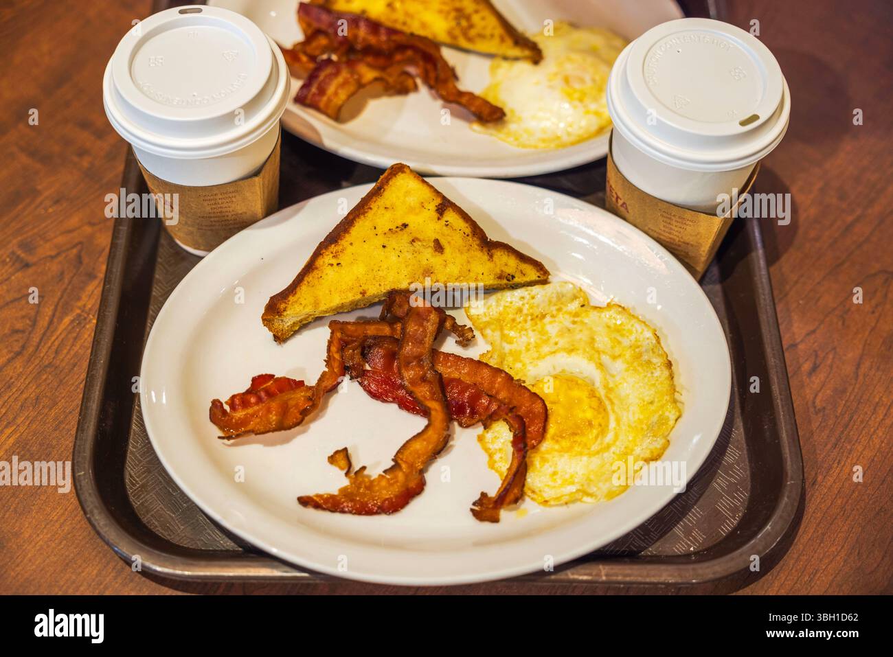 Classic American breakfast with fried eggs, crispy bacon, toast and ...