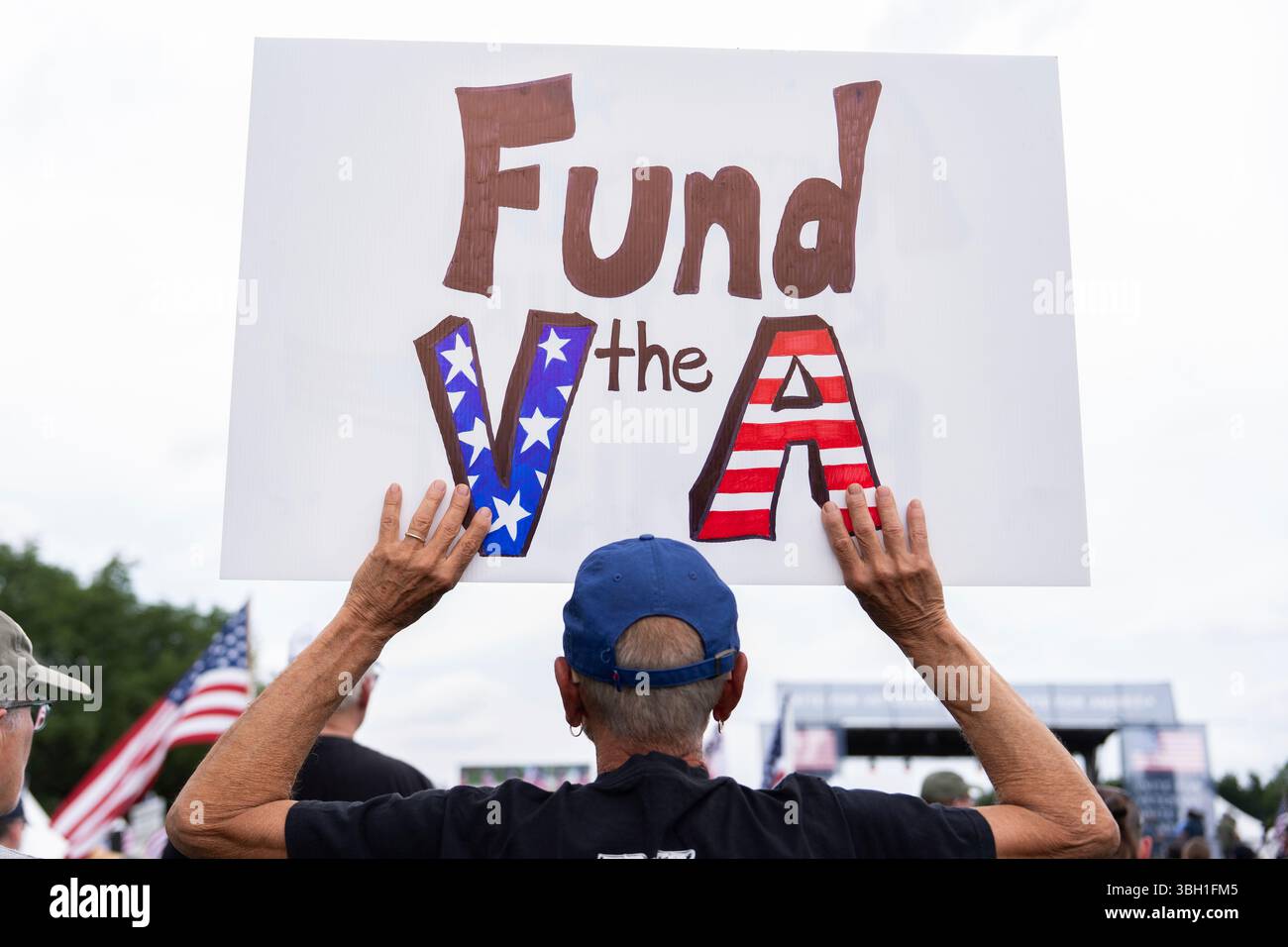 A demonstrator holds a sign at a Unite for Veterans rally, Friday, June ...