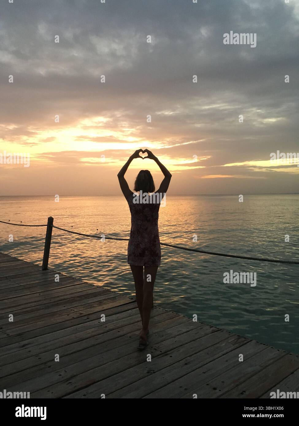 Hands above head making heart shape hi-res stock photography and images ...