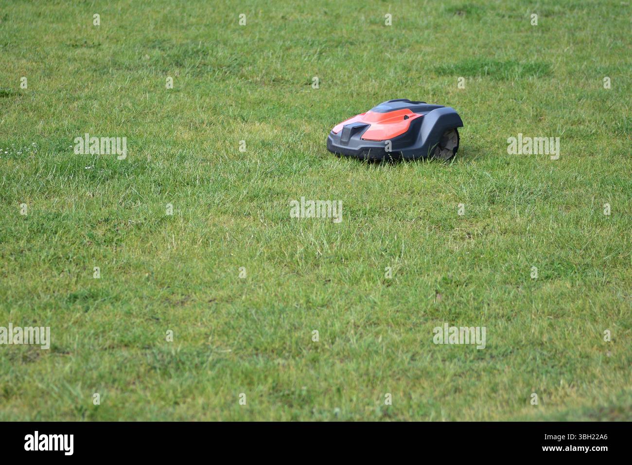 Autonomous robotic lawn mower working on a grass. Smart garden ...