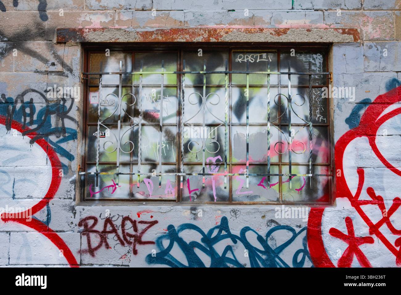 A vandalized wall & barred window along Main Street in Vancouver, BC ...