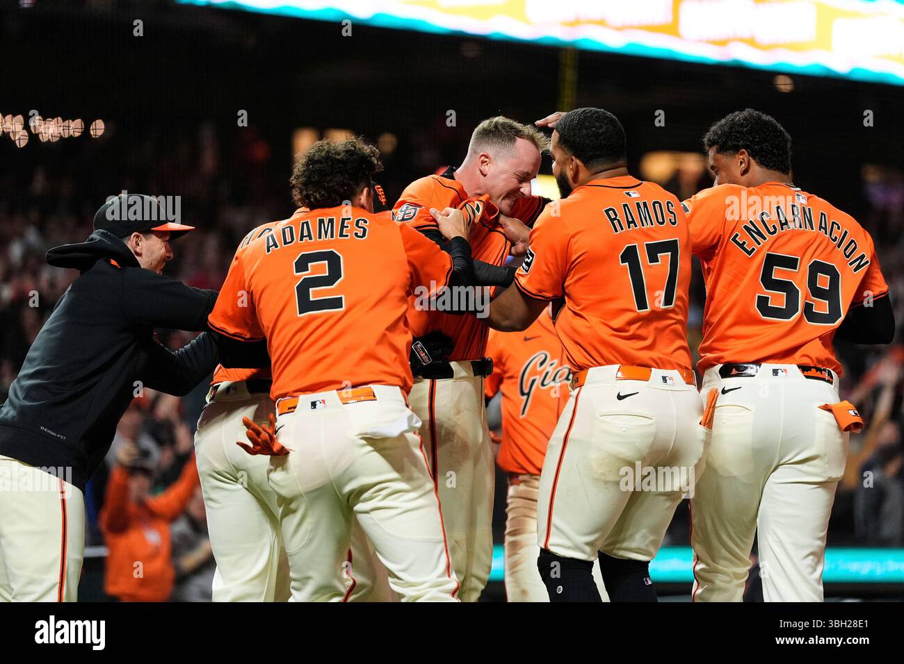San Francisco Giants' Tyler Fitzgerald, center, is mobbed by teammates ...