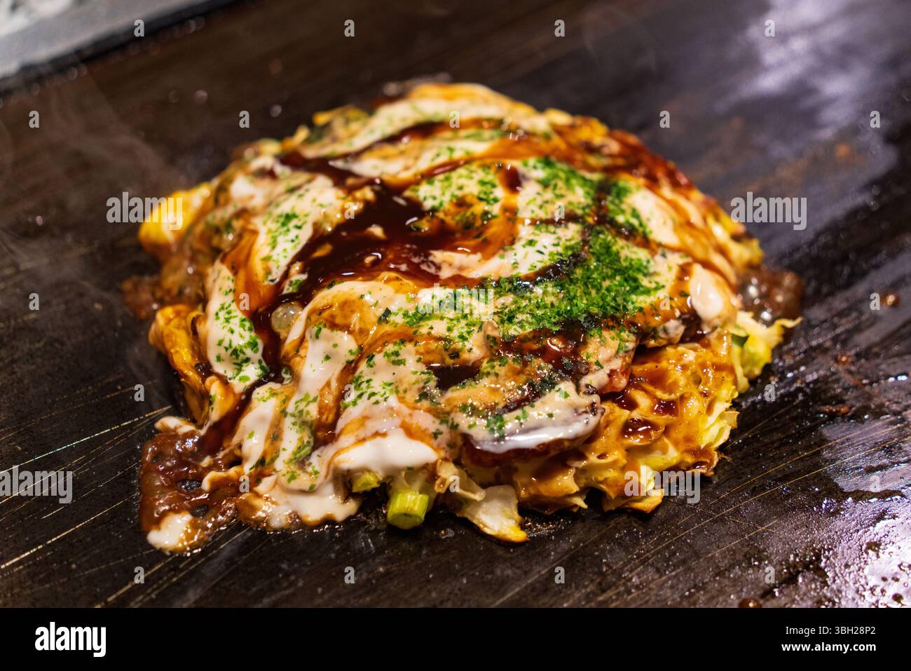 Okonomiyaki, a traditional japanese cuisine in Osaka, Japan Stock Photo ...