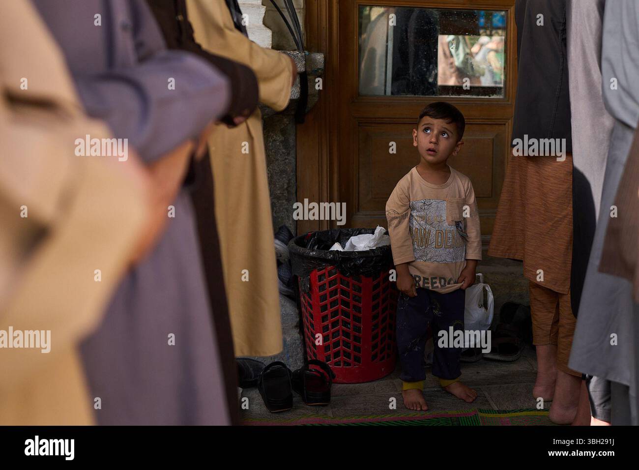 A boy watches men pray during Eid al Adha in Kabul, Afghanistan ...