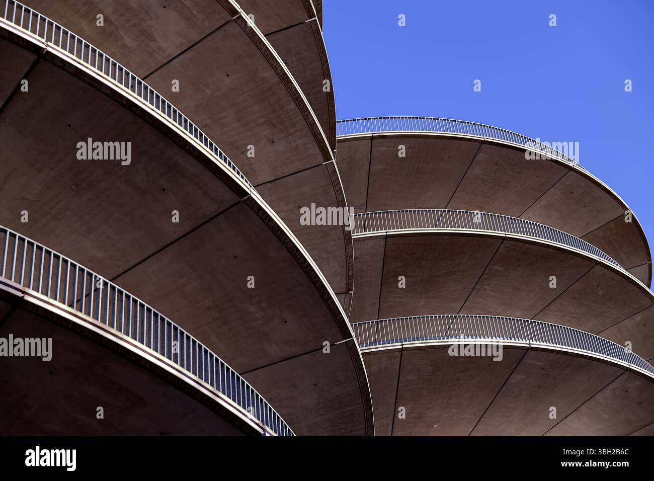 Spiral car park in Amsterdam with warm sunlight casting shadows on ...