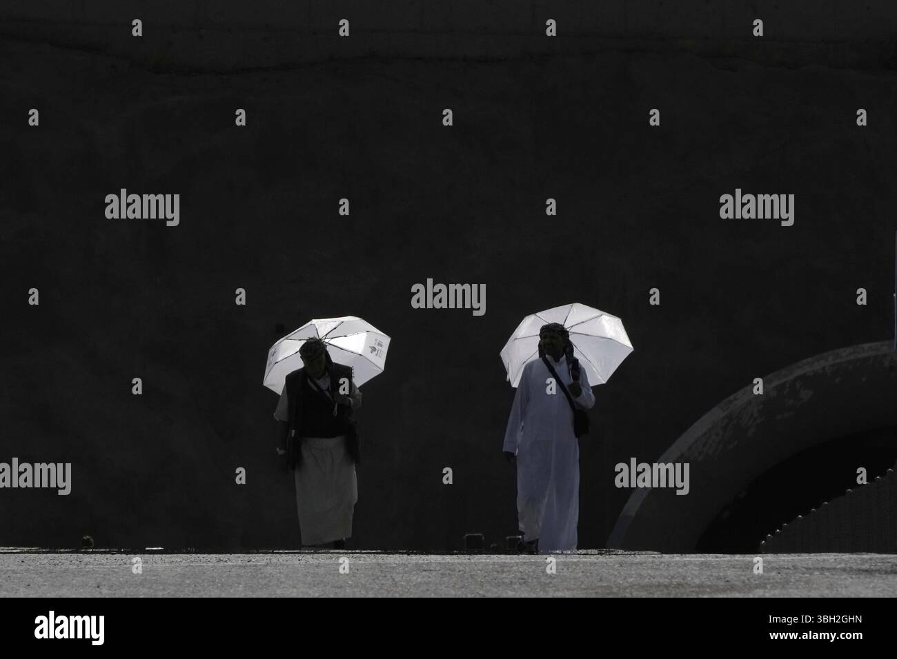 Muslim pilgrims walk to cast stones at pillars in the symbolic stoning ...