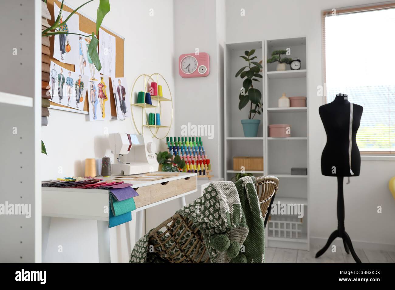 Interior of light atelier with tailor's workplace, shelf unit and ...