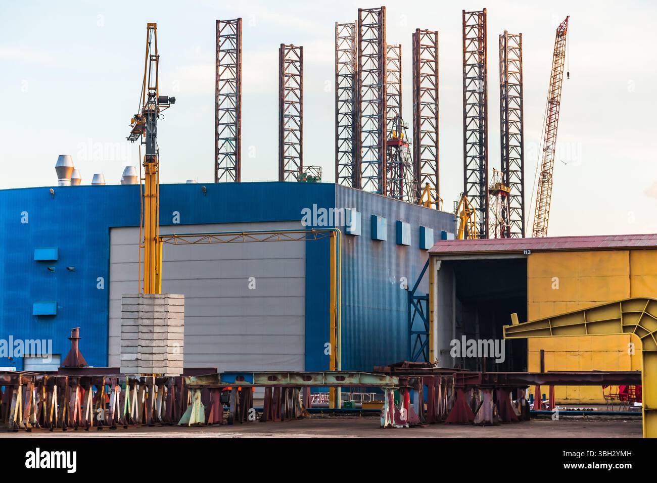 The territory of the shipyard with industrial warehouses and cranes ...