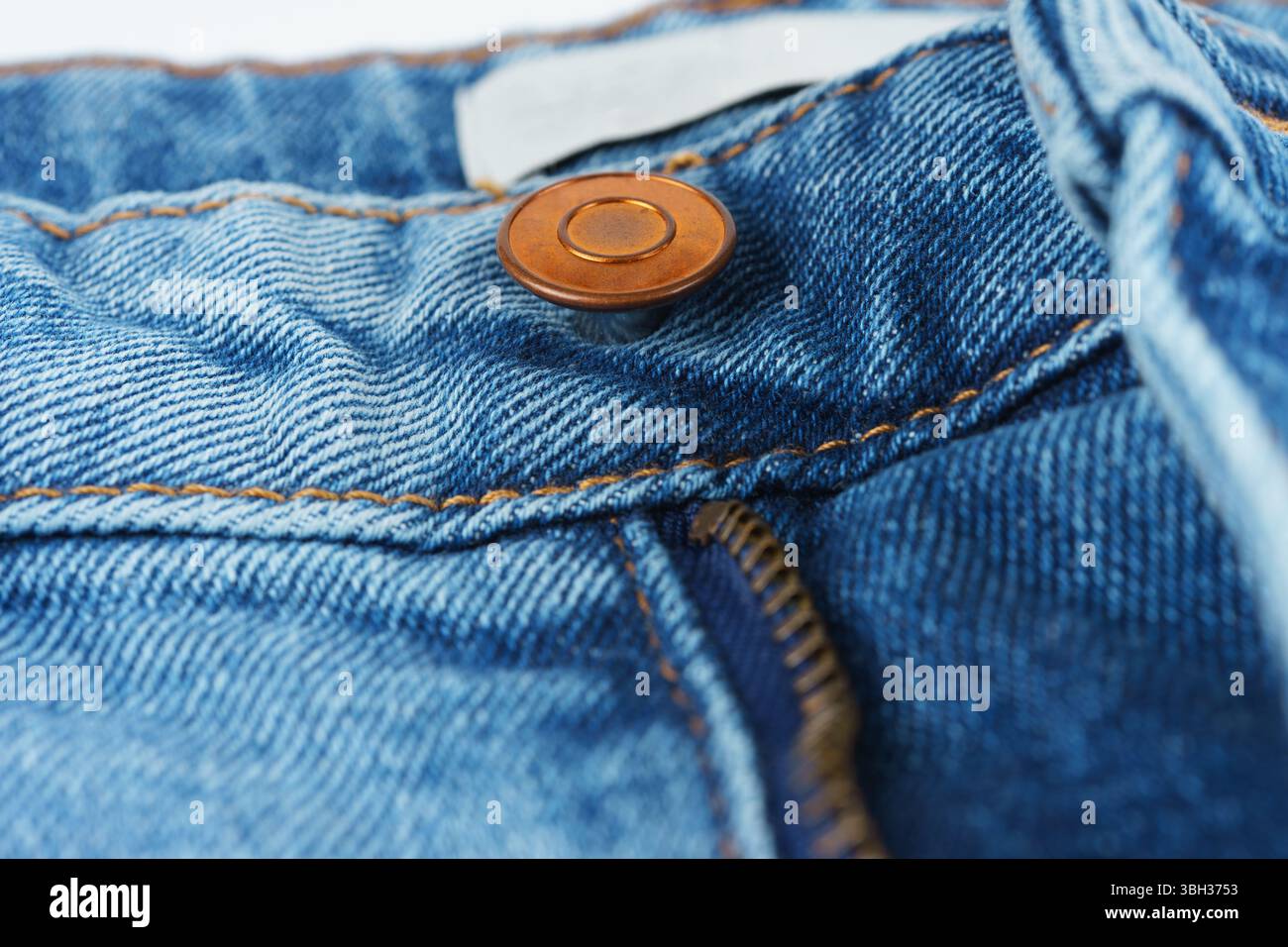 Macro photo of blue denim jeans showing metal copper button and zipper ...