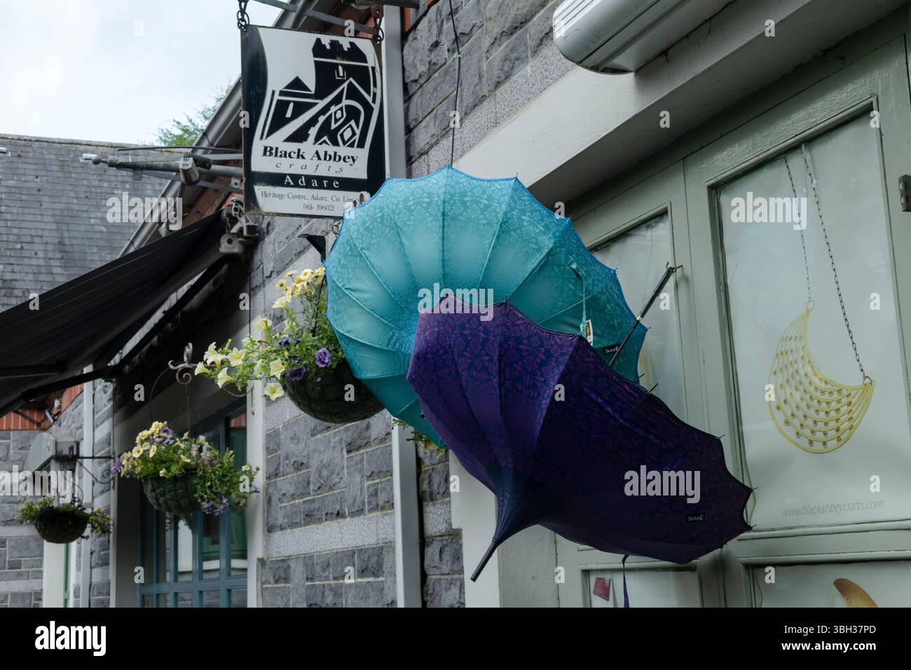 Hanging open rain umbrellas outside Black Abbey Crafts building Stock ...