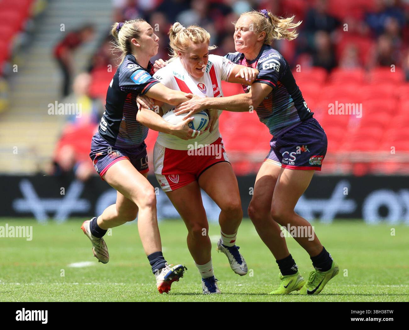St Helens' Amy Hardcastle (centre) is tackled Wigan Warriors' Georgia ...