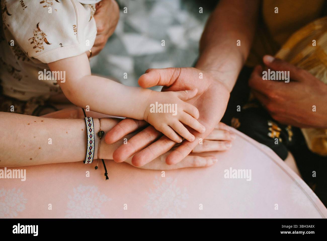 A tender moment is captured as multiple hands come together ...