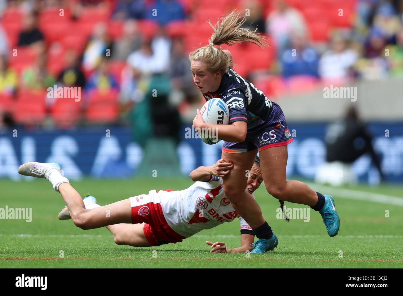 Wigan Warriors' Ellise Derbyshire (right) is tackled by St Helen’s Zoe ...