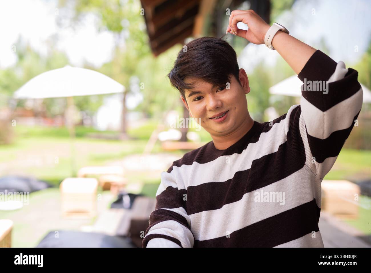 Young Cute Gay Man Sitting Outdoors In Cafe Restaurant During Day Stock