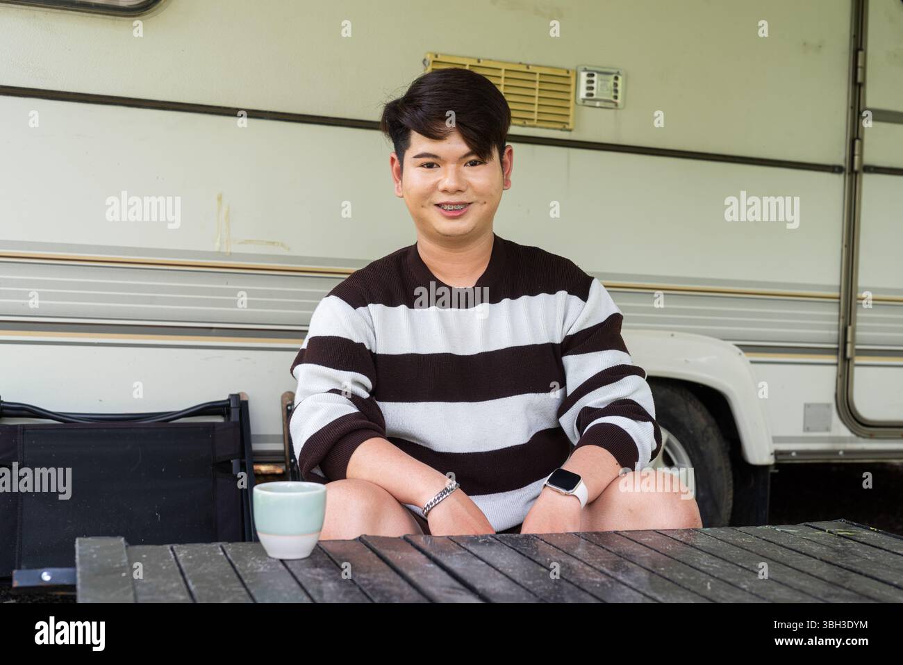 Happy young Asian gay man enjoying campsite camping lifestyle with van ...