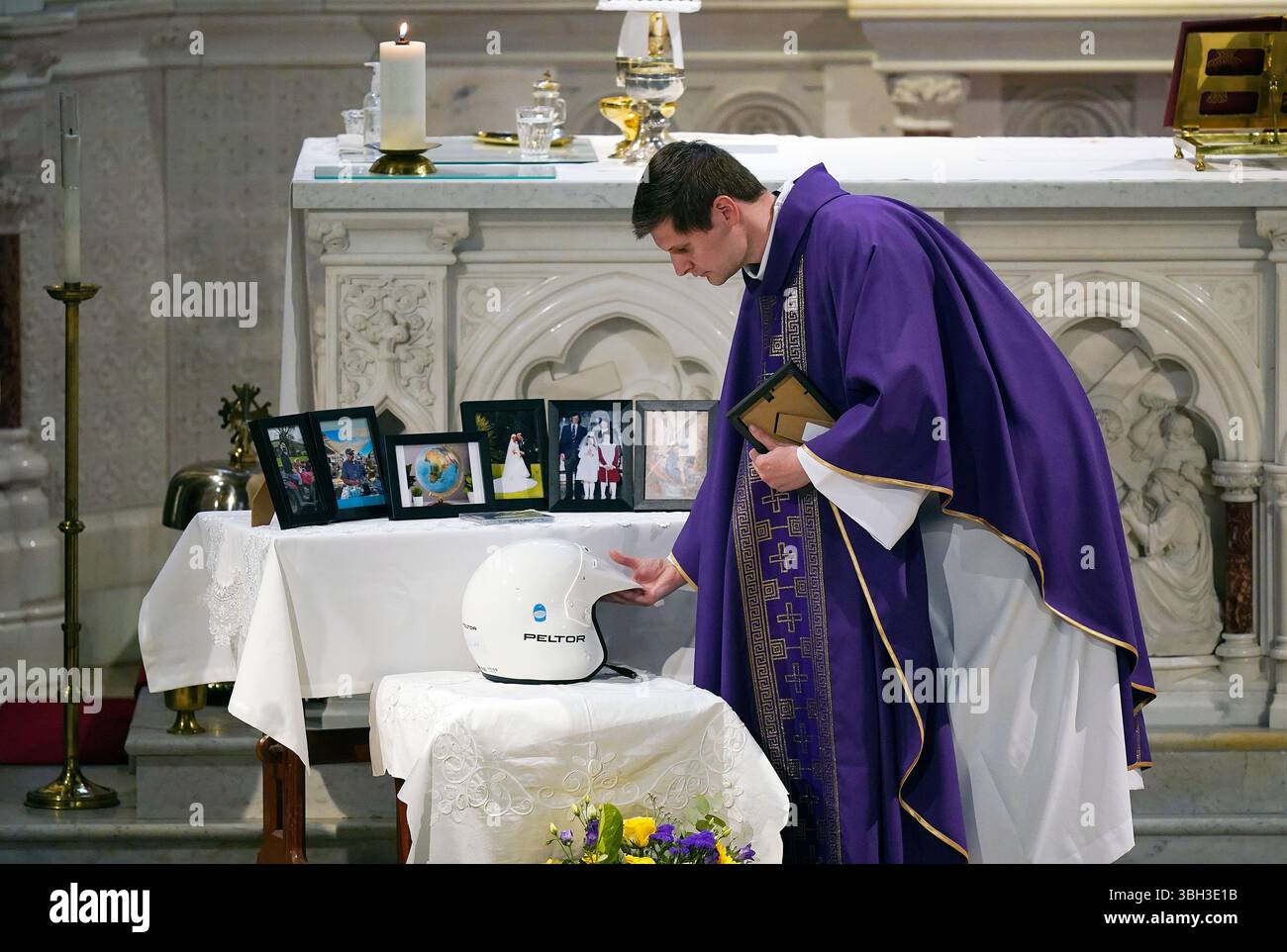 Fr Sean Murphy places a rally helmet on the alter during the funeral ...
