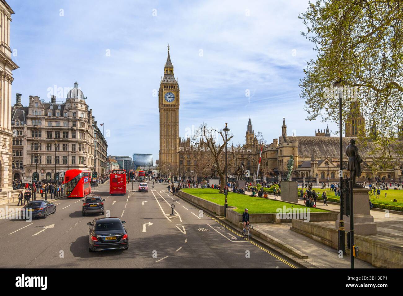 Busy Parliament Square Garden scene with Big Ben, Parliament, red buses ...