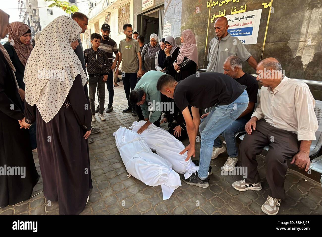 Palestinians inspect the damage at the site of an Israeli strike on a ...