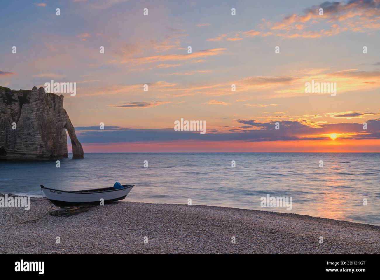 An evening during sunset on the pebble beach of Etretat, Normandy ...