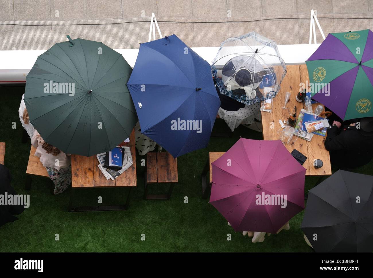 Racegoers with umbrellas during Derby Day of the Betfred Derby Festival ...