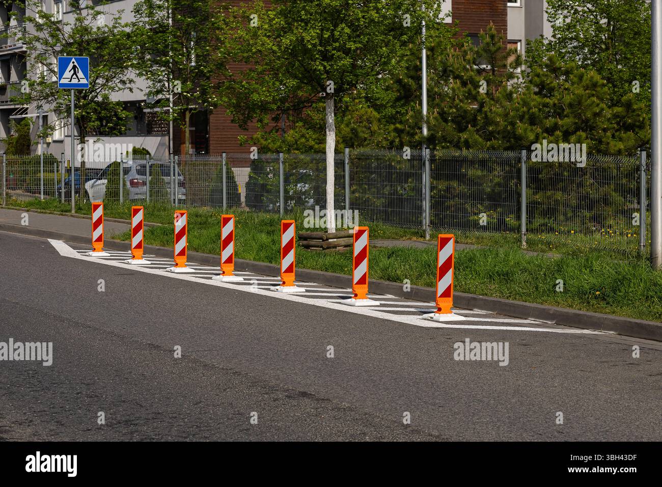 Bright red and white reflective road safety bollards near pedestrian ...