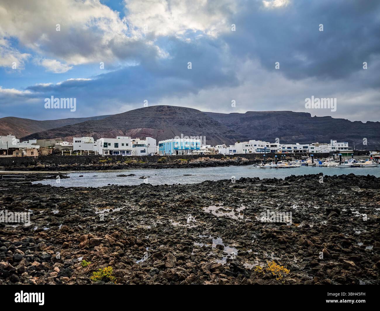 Orzola village in Lanzarote features fishing boats on rocky shores ...