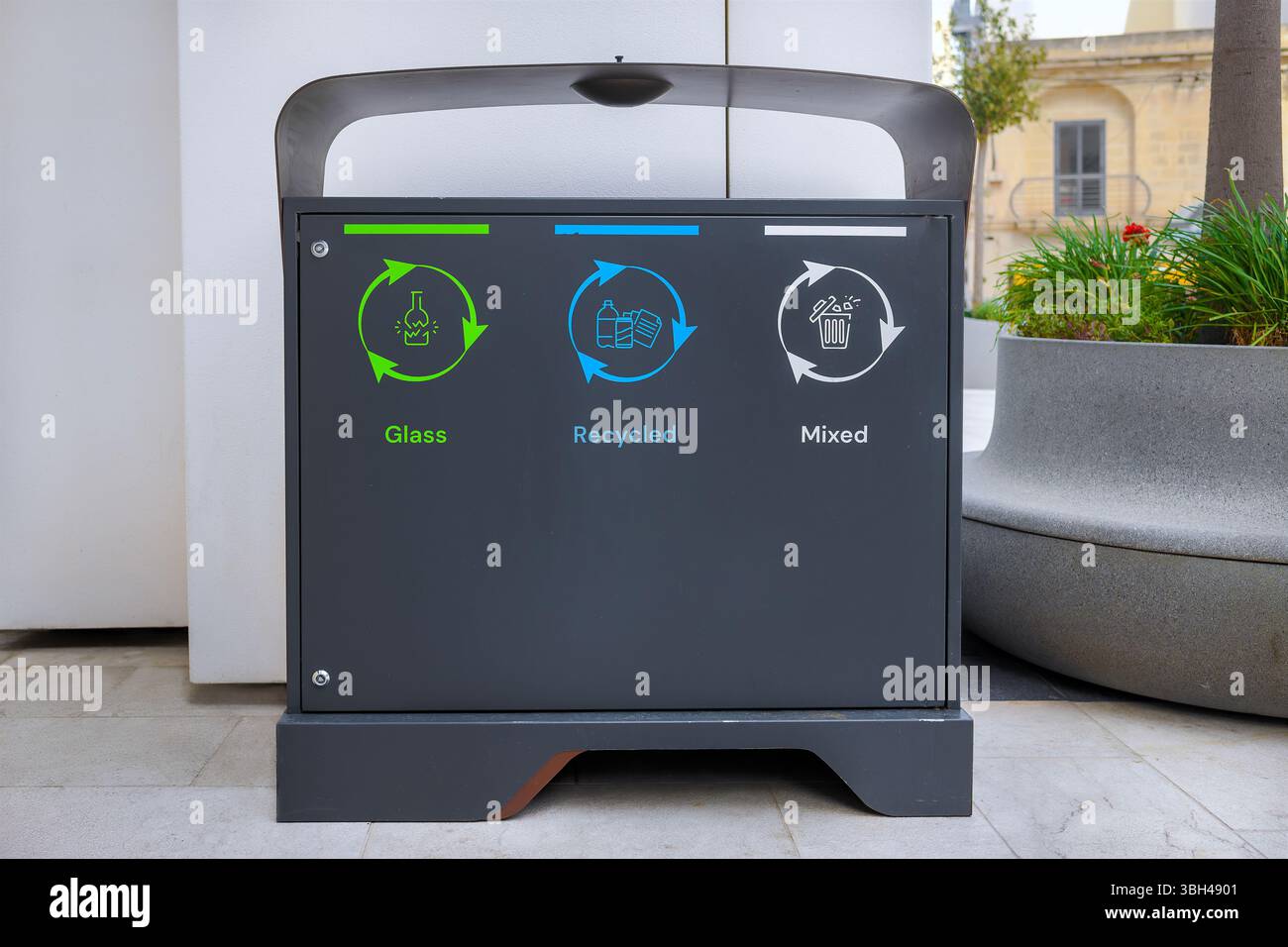 Modern public recycling bin with three labeled sections: glass (green ...