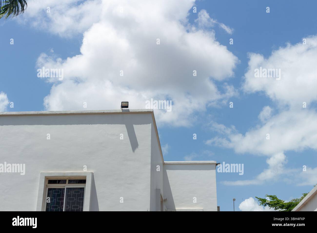 Detail of a modern, flat-roofed building. The stark white walls ...
