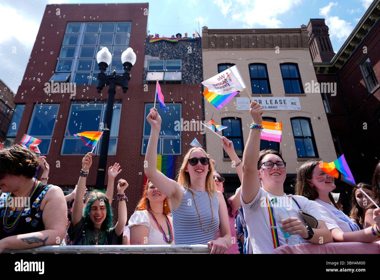 People wave flags as they watch the World Pride parade, Saturday, June ...