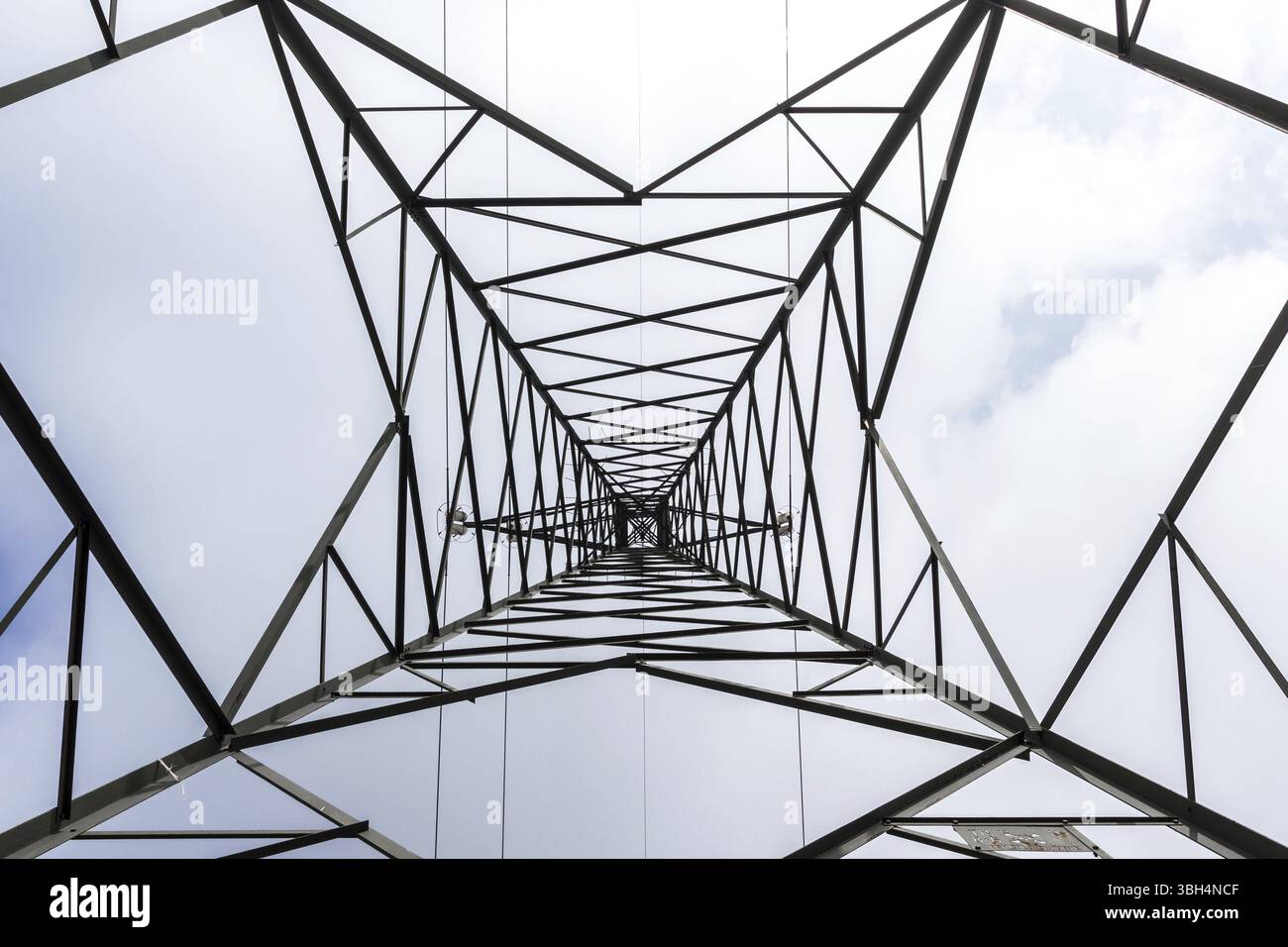 High voltage pylon against cloudy sky. Bottom view. Pattern of metal ...