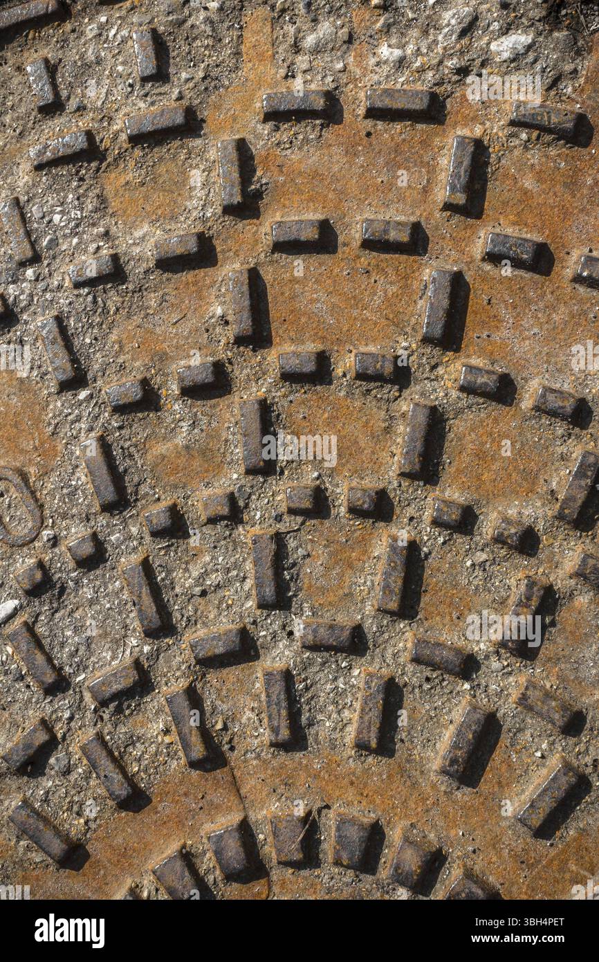 Relief pattern of rusty manhole cover in closeup Stock Photo - Alamy