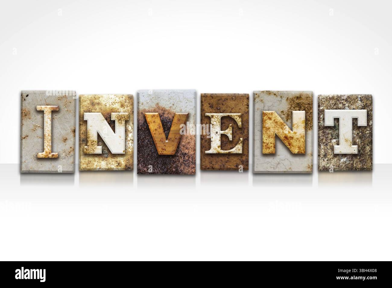 The word INVENT written in rusty metal letterpress type isolated on a ...