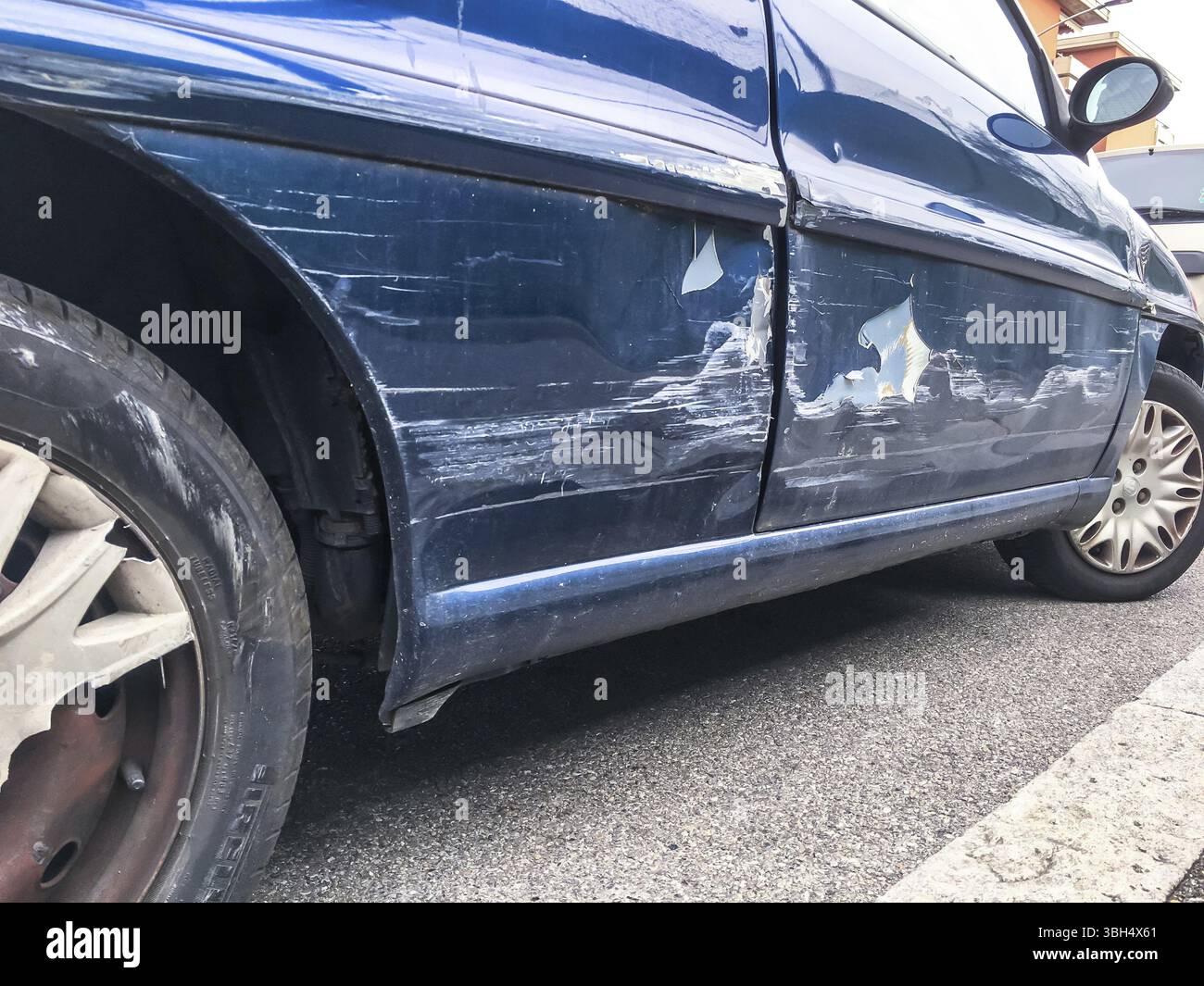 Blue car, dent in a door in the street after a broken accident ...