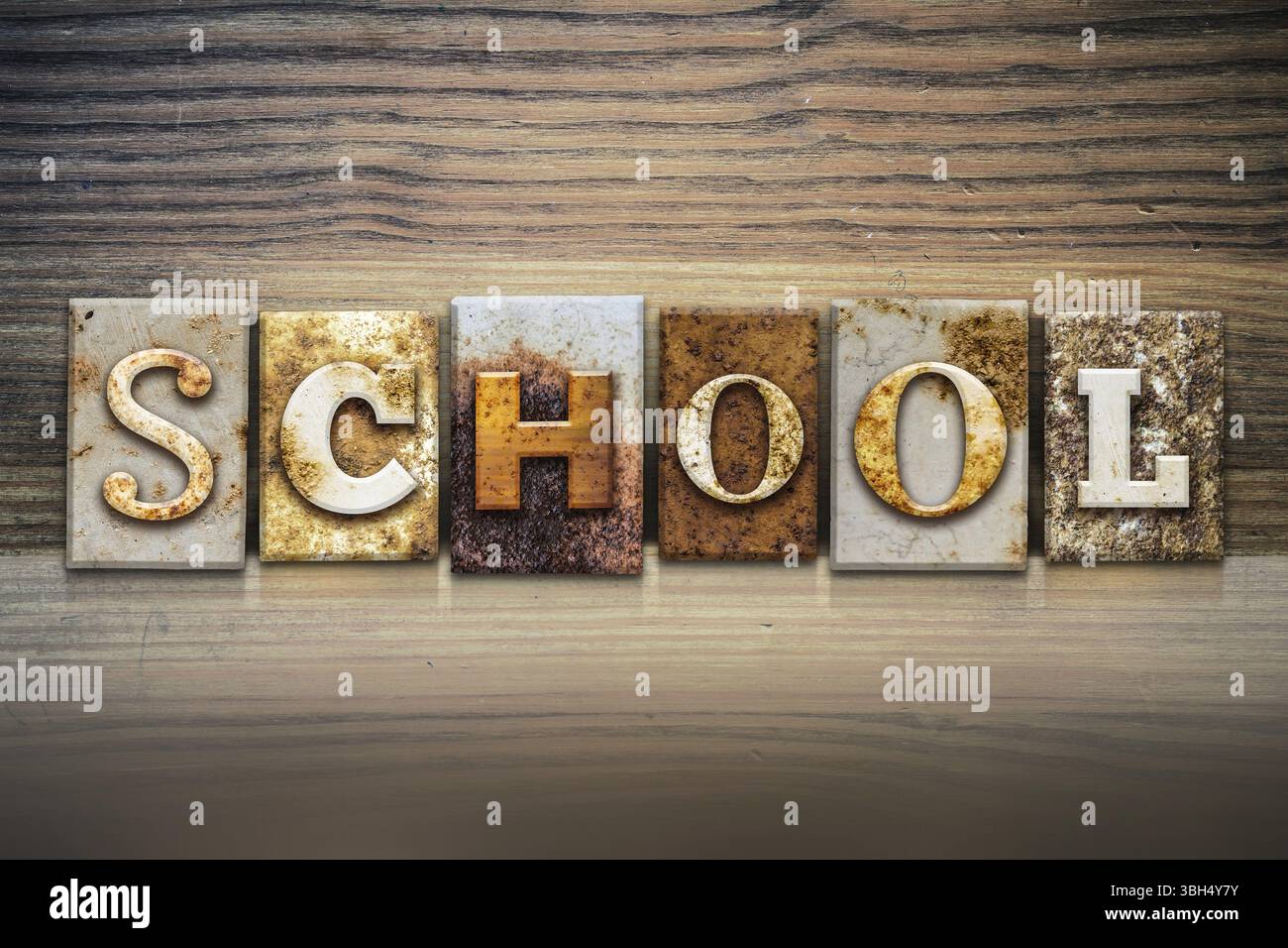 The word SCHOOL written in rusty metal letterpress type sitting on a ...