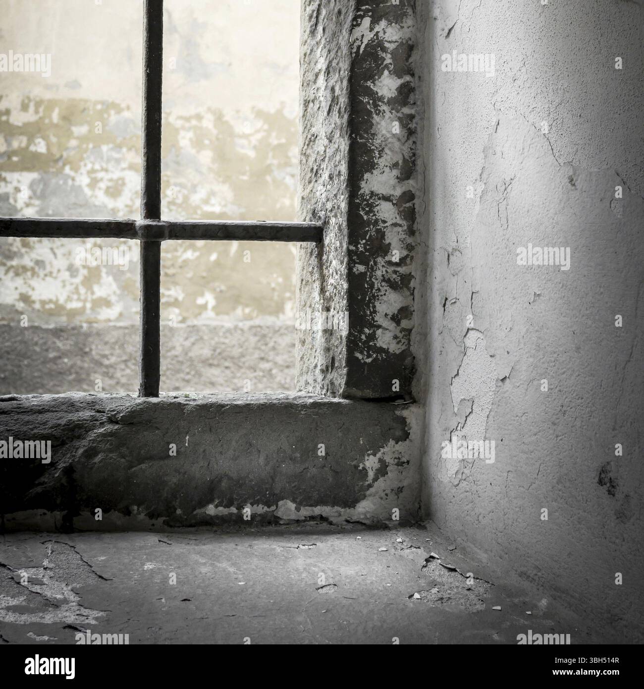 Old grunge prison with sun rays breaking through a barred window ...