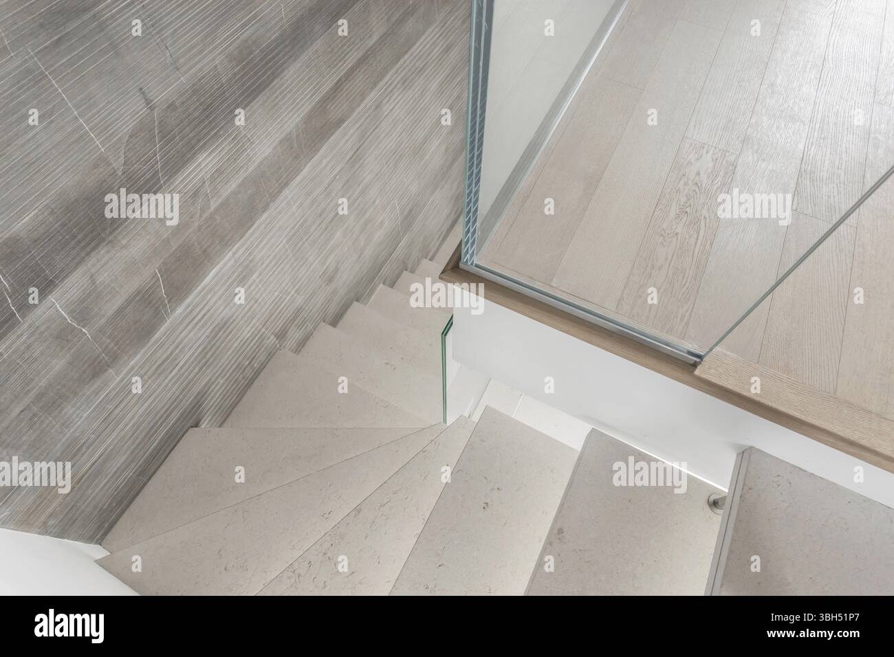 Grey microcement stairs with glass handrail. Stairs viewed from above ...