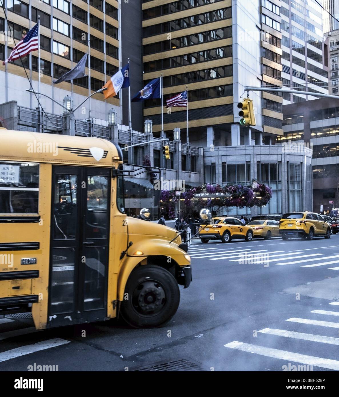 Typical New York street scene with yellow school bus and yellow taxis ...