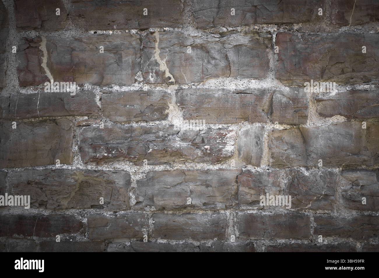 Front view of a stone wall slightly illuminated Stock Photo - Alamy