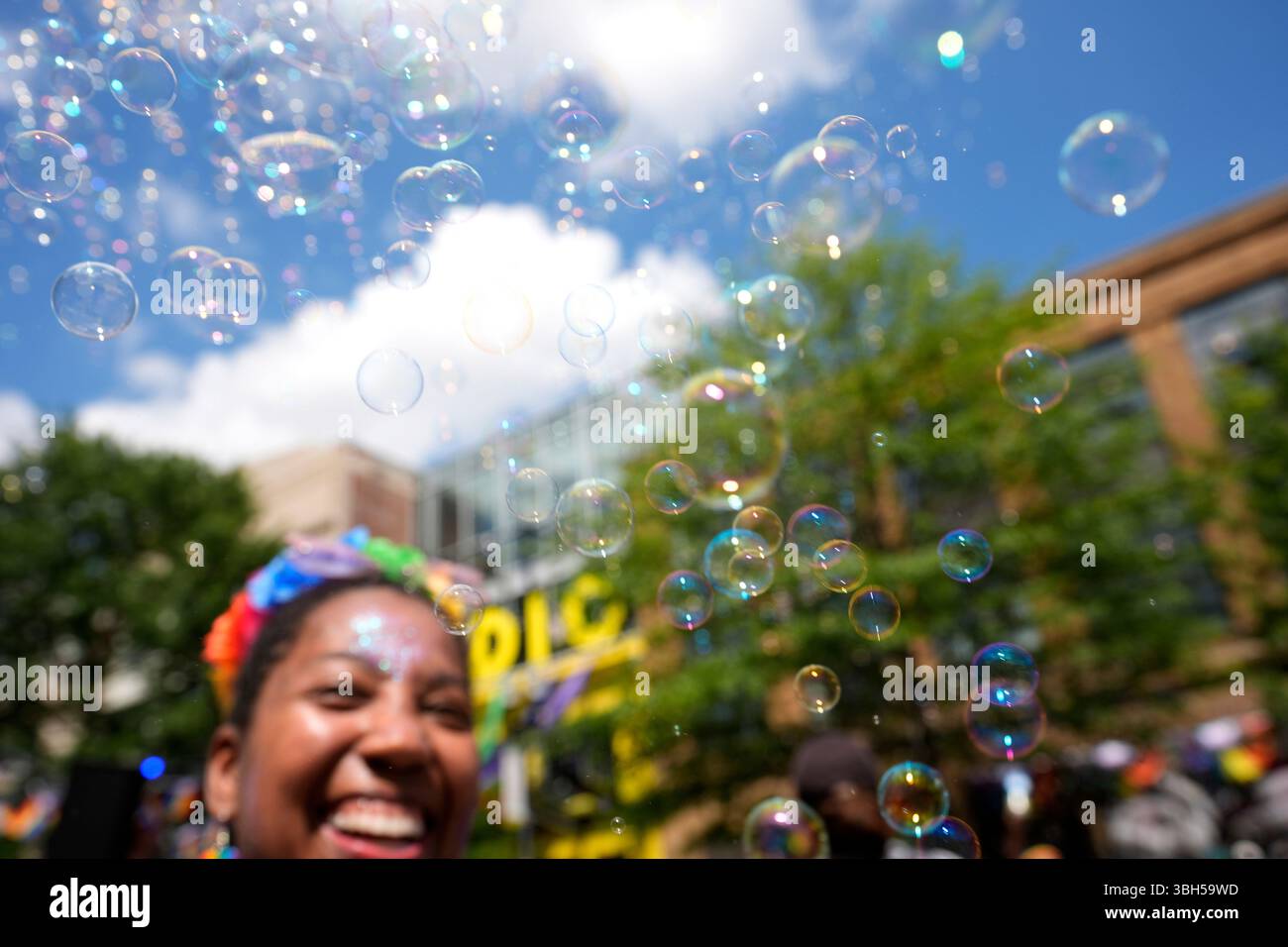 Bubbles float as a person watches the World Pride parade, Saturday ...