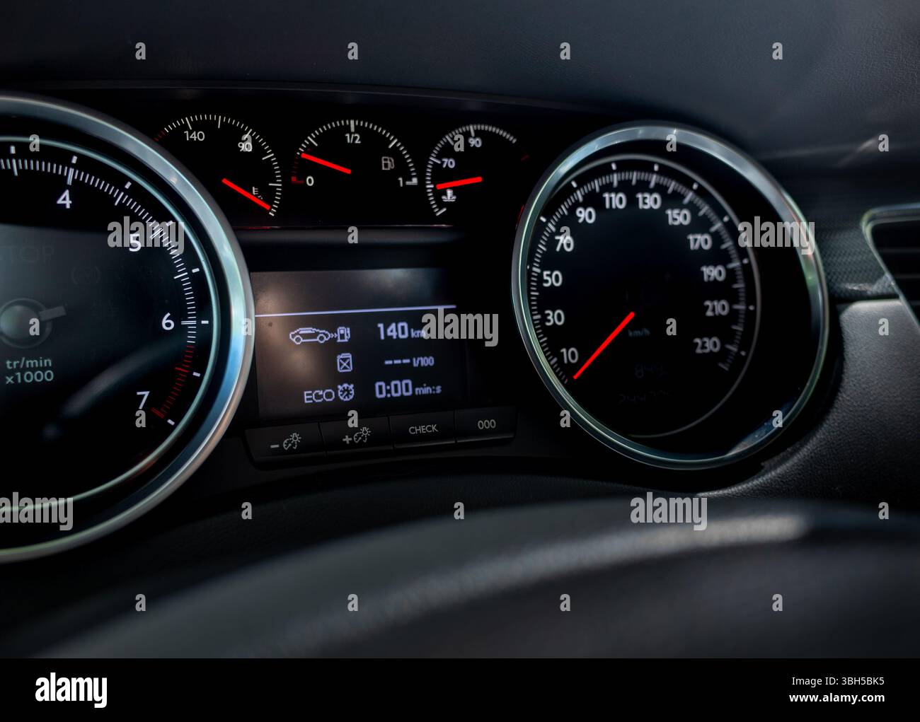Detailed view of a modern car dashboard showing illuminated tachometer ...