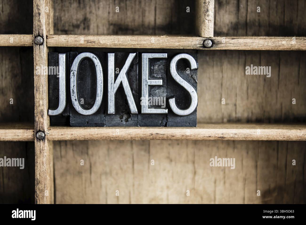 The word JOKES written in vintage metal letterpress type in a wooden ...