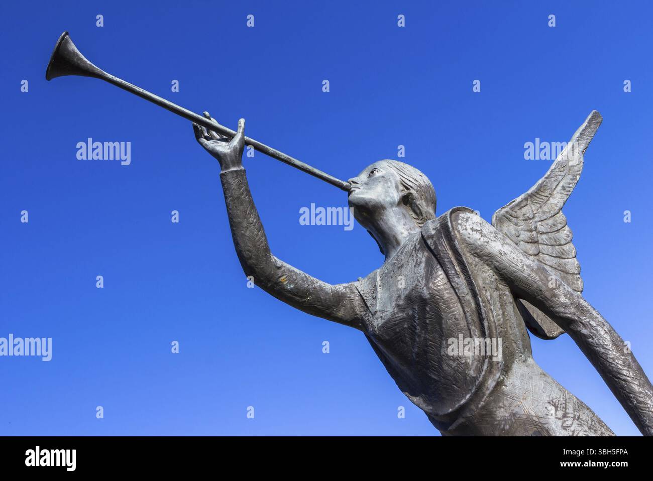 Statue of an angel playing a trumpet over blue sky Stock Photo - Alamy