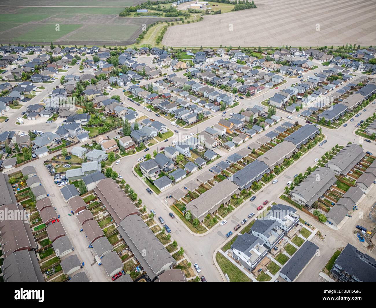 Residential area with many houses and cars. The houses are mostly white ...