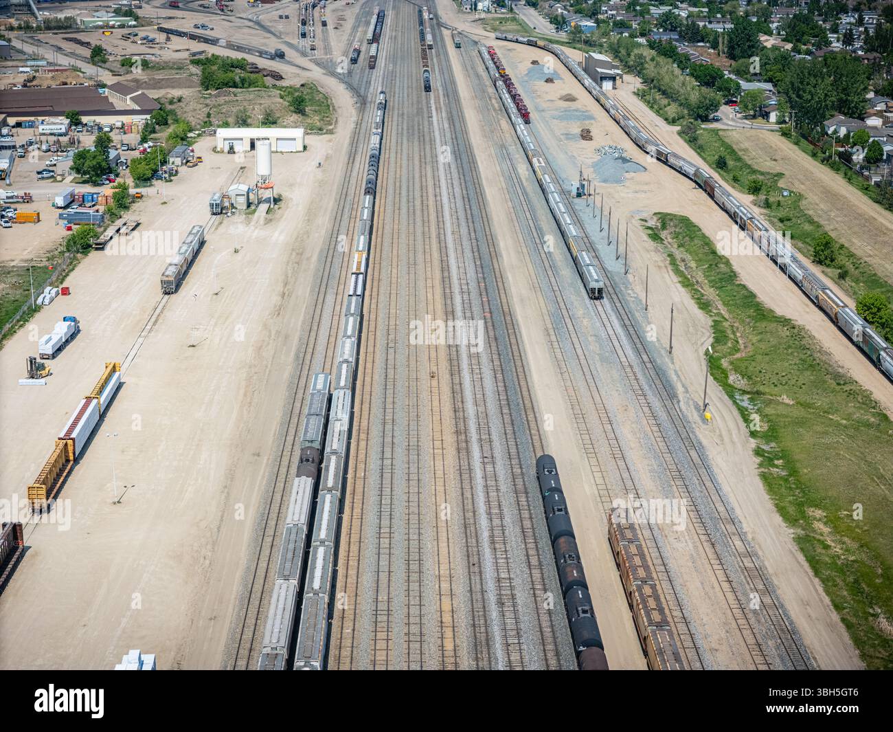 Train yard with many trains on the tracks. The trains are mostly black ...