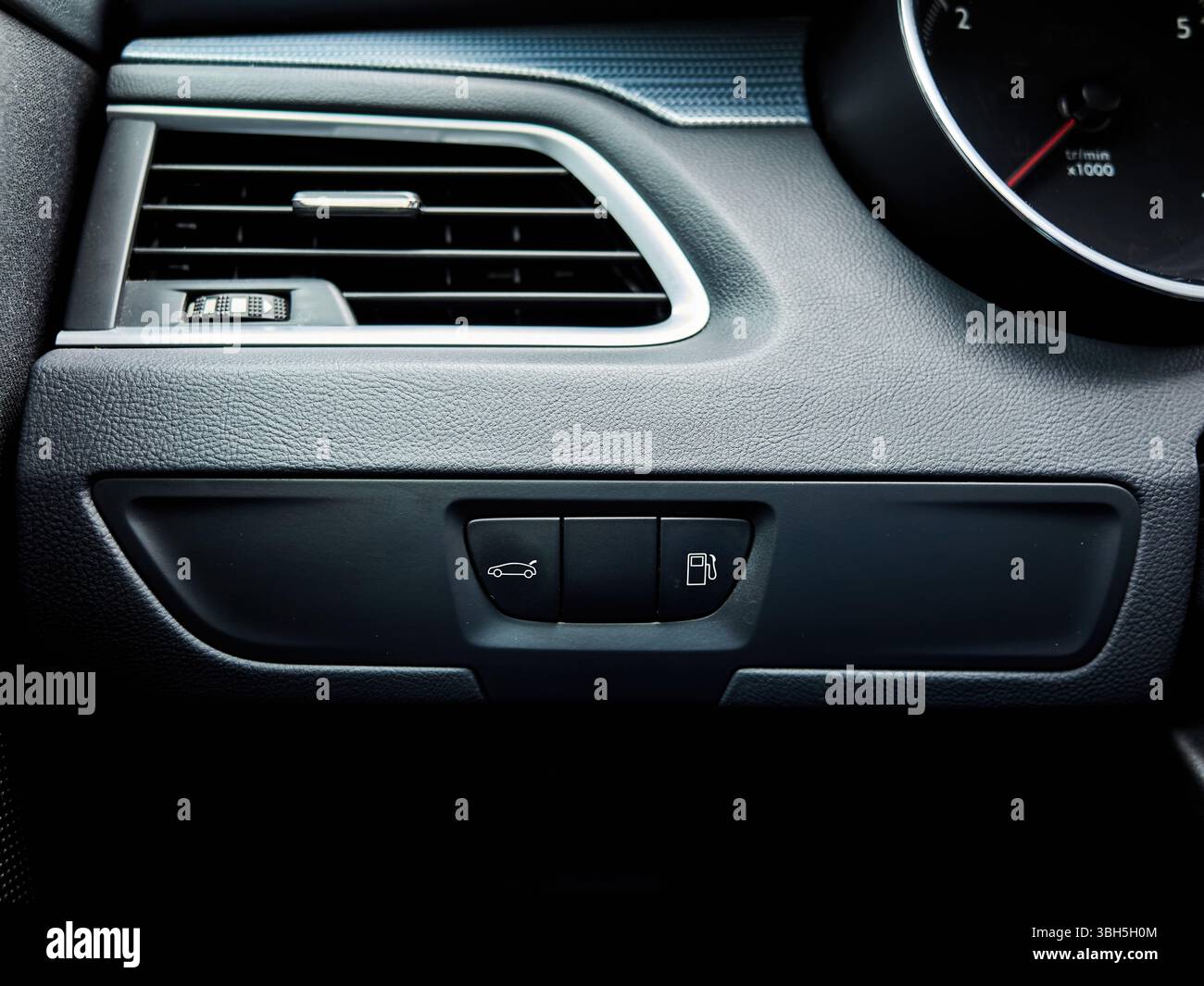 The dashboard of a car has a small compartment with a vent. The vent is ...
