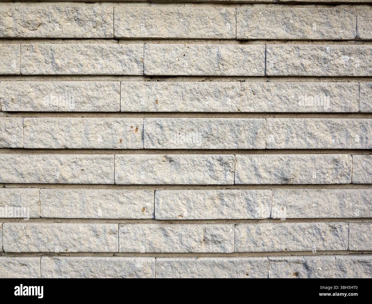 Wall made of white bricks. The bricks are not perfectly aligned. There ...