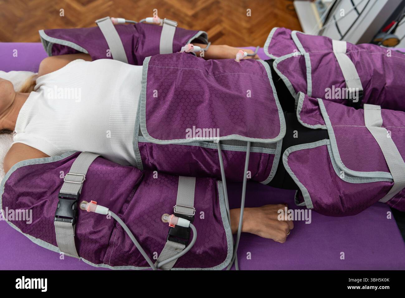 Woman undergoing pressotherapy, using a specialised suit with ...